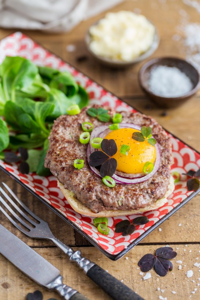 Beef patty open sandwich with raw egg yolk • Electric Blue Food